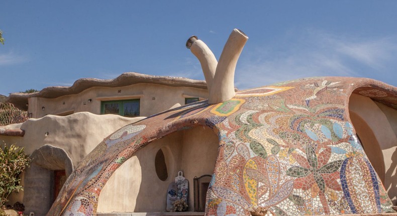 A mosaic-encrusted curved shell home was built after a devastating ...